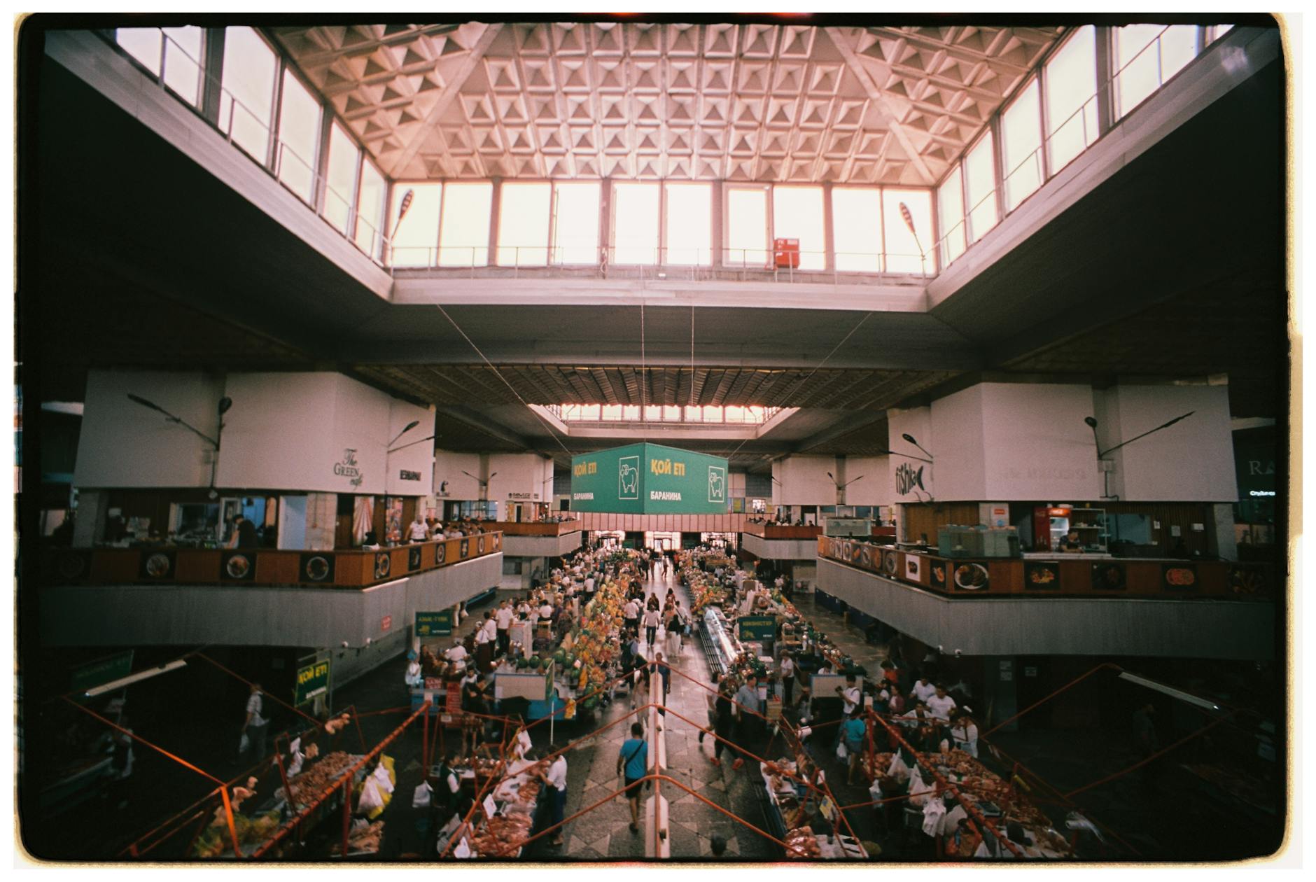 Interior of a Lisbon market hall with geometric ceiling and shoppers browsing food stalls