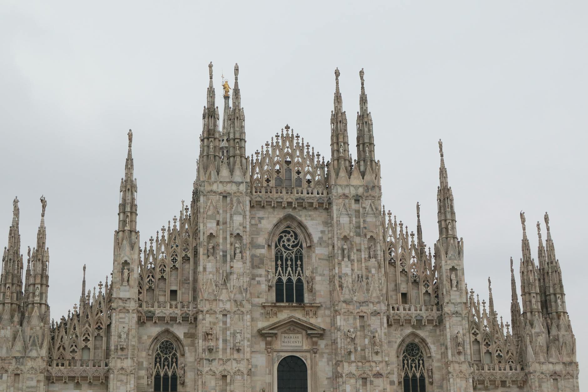 Close-up view of Milan Cathedral Gothic facade and spires