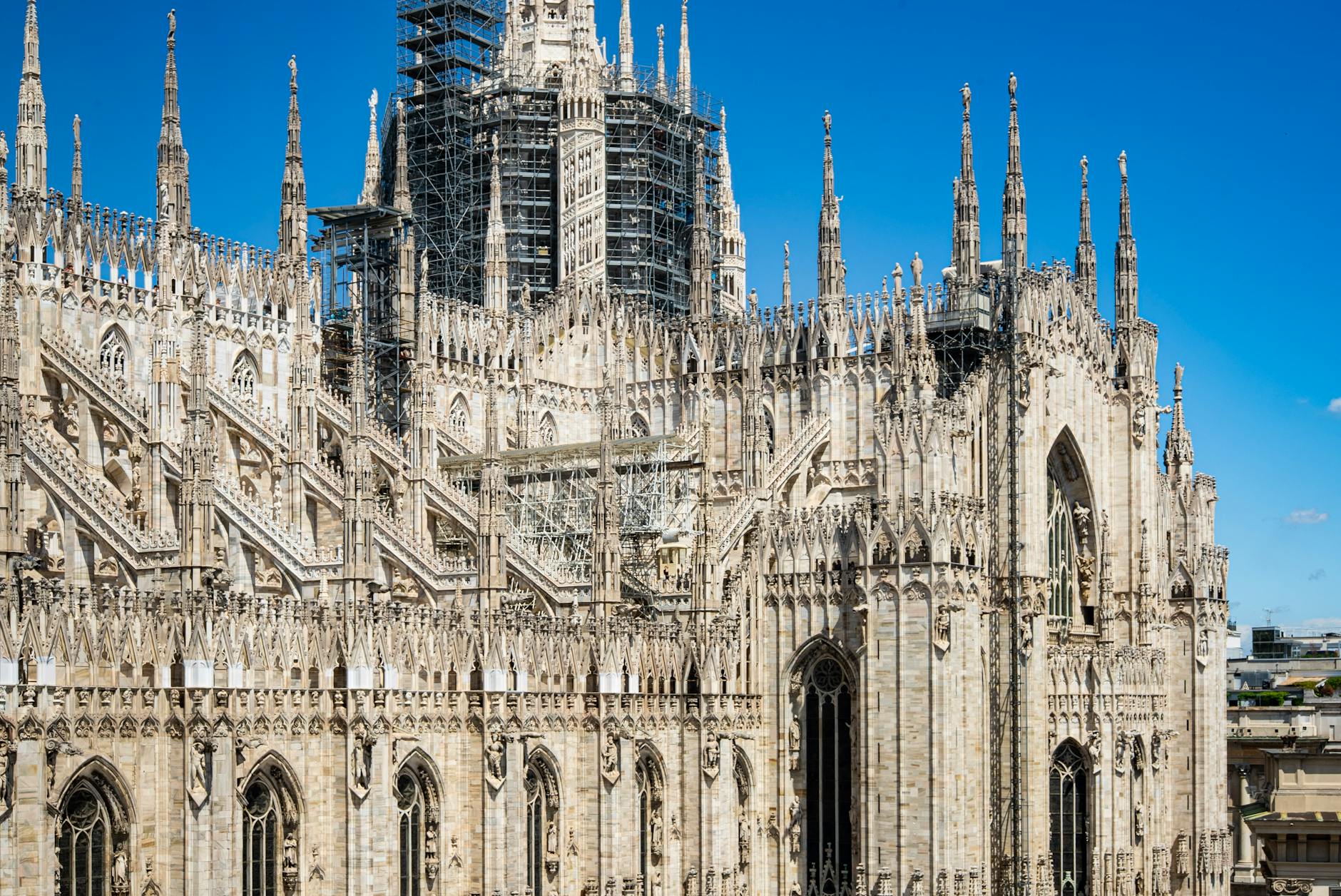 The Gothic facade of Milan Duomo Cathedral against a blue sky
