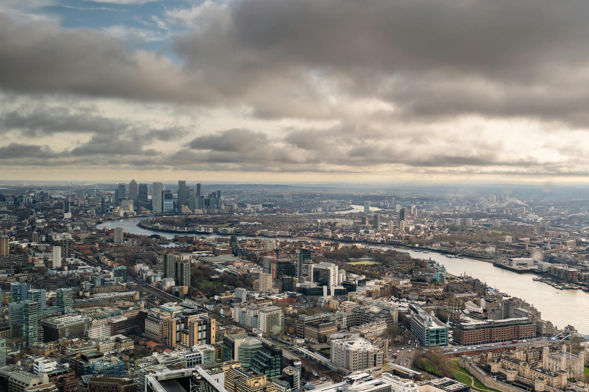 Aerial photograph of London showing the River Thames winding through the city with skyscrapers and historic buildings