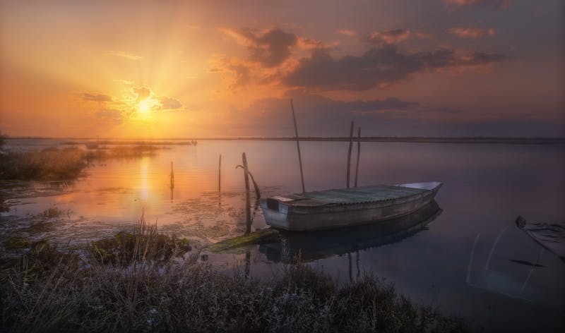 Serene sunset view over the Venetian lagoon with a solitary boat on calm waters