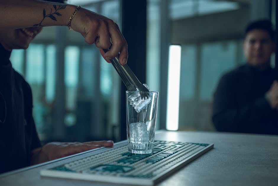 Bartender adding ice to a glass in a modern bar