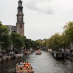 View of Amsterdam canal with the Westerkerk tower rising above traditional Dutch canal houses
