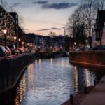 Beautiful canal in Amsterdam during twilight with reflections on water