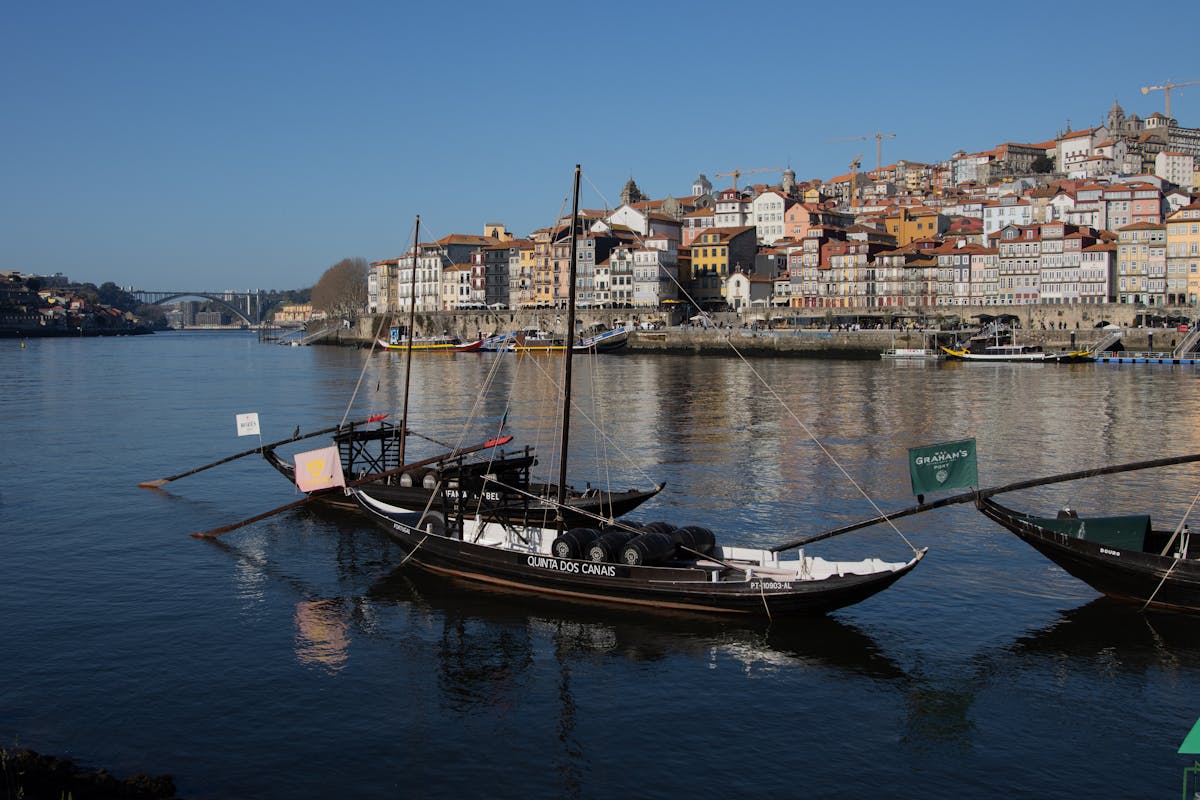 Traditional wooden boats on the Douro River with colorful Porto buildings rising behind them