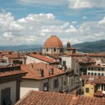 Florence rooftops and cathedral dome under partly cloudy sky
