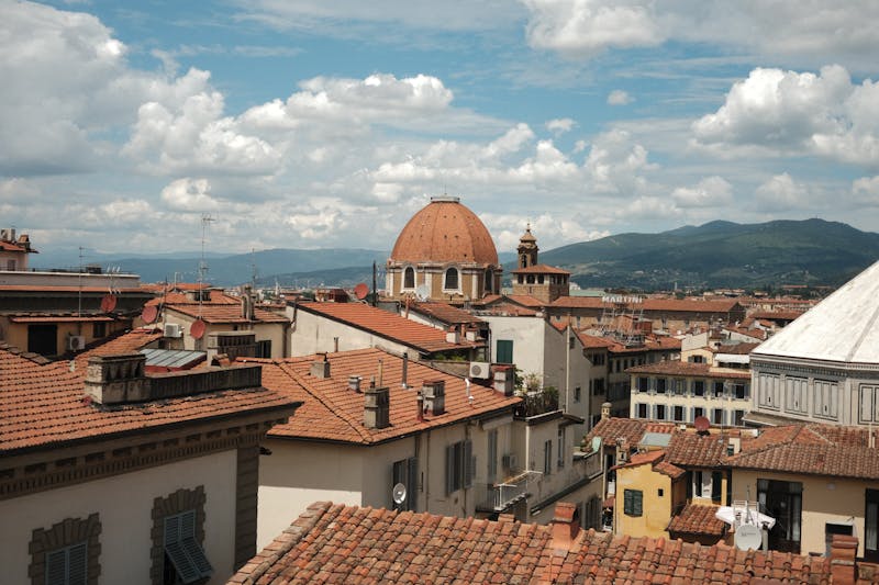 Florence rooftops and cathedral dome under partly cloudy sky