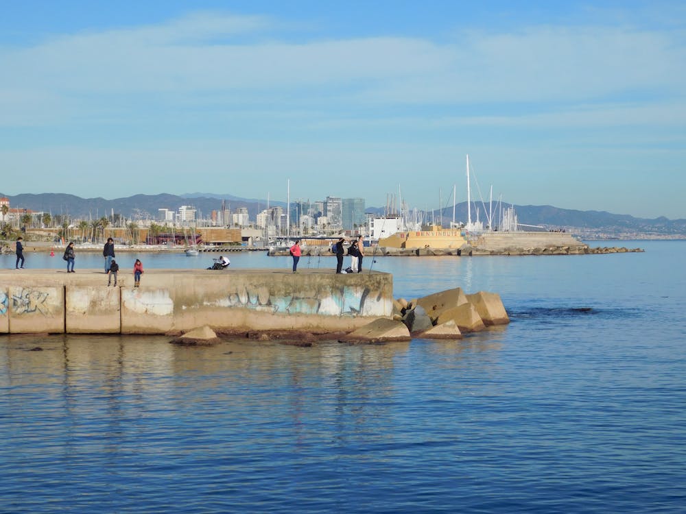 Picturesque view of Barcelona coastline with people enjoying a sunny day by the water
