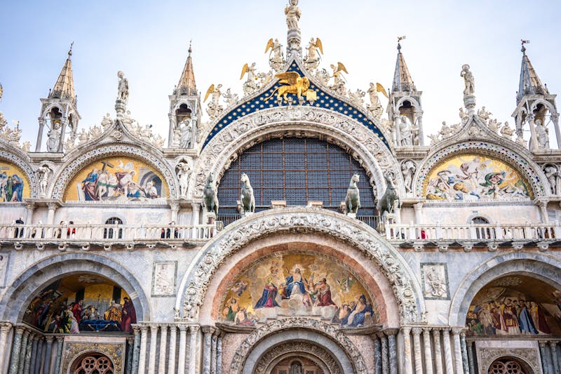 The ornate golden facade of St Marks Basilica showcasing detailed mosaics and arches