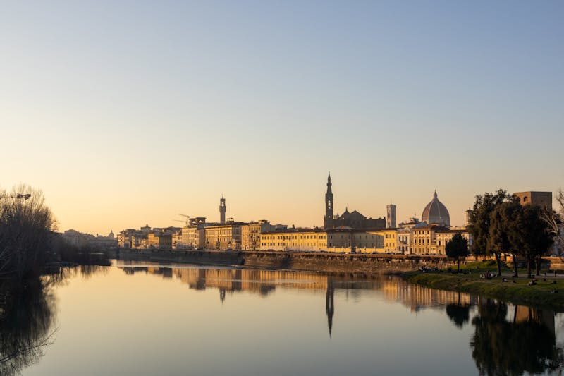 Peaceful sunset view of Florence with the Arno River reflecting the historic skyline