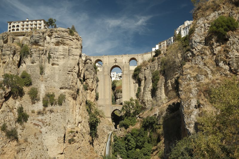 Scenic view of the Puente Nuevo bridge spanning El Tajo Gorge in Ronda with surrounding greenery