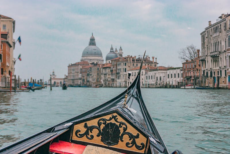 View from a gondola on Venices Grand Canal looking toward St Marks Basilica and waterfront buildings