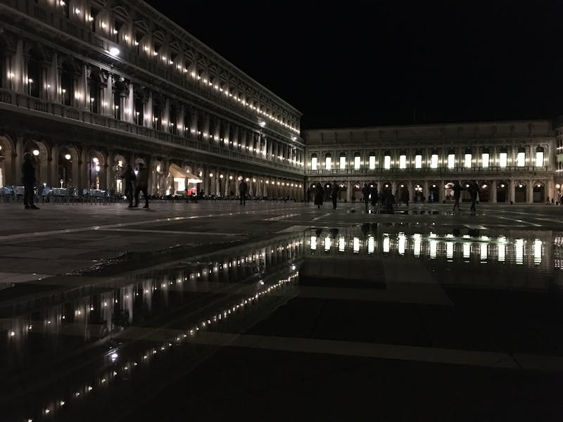 St Marks Square in Venice at night with ambient lighting and reflections on wet pavement