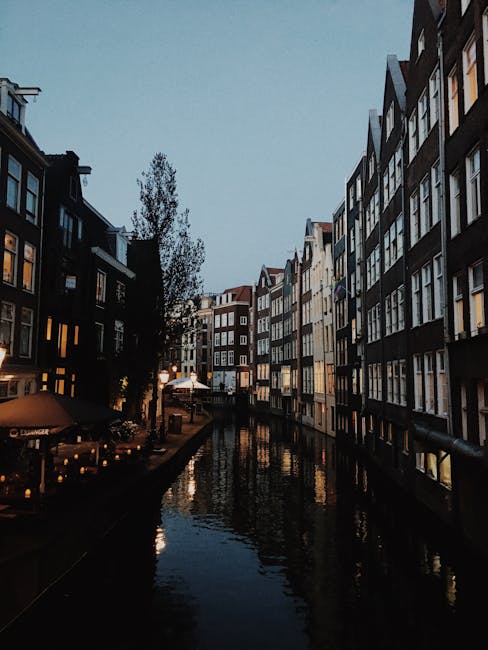 Evening scene of a canal in Amsterdam with lights reflecting on water