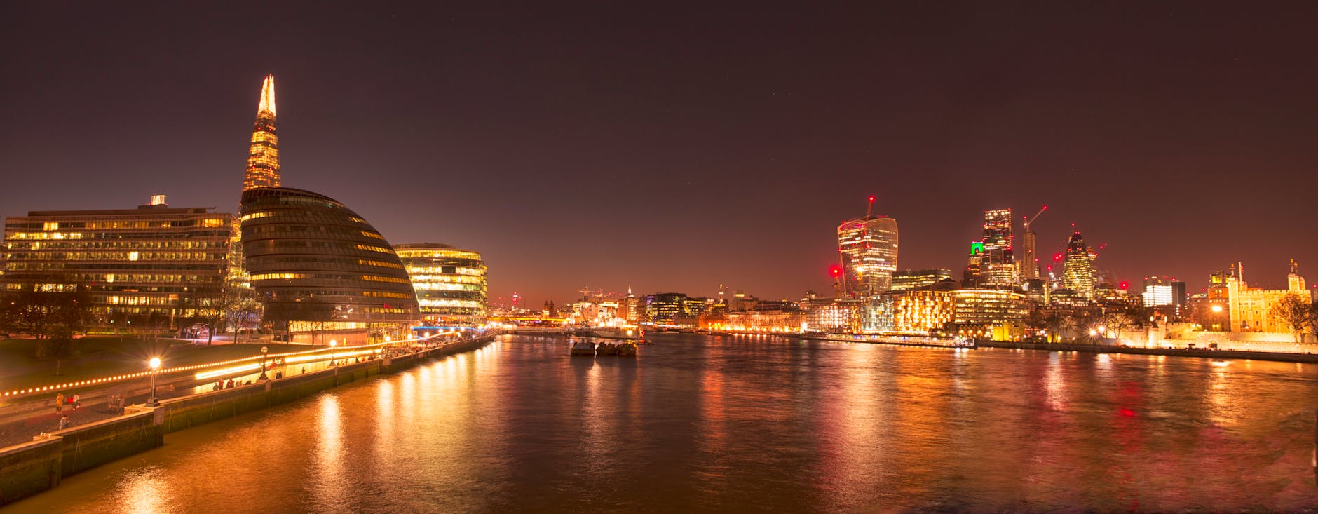 Night view of London skyline with lights reflecting on the River Thames