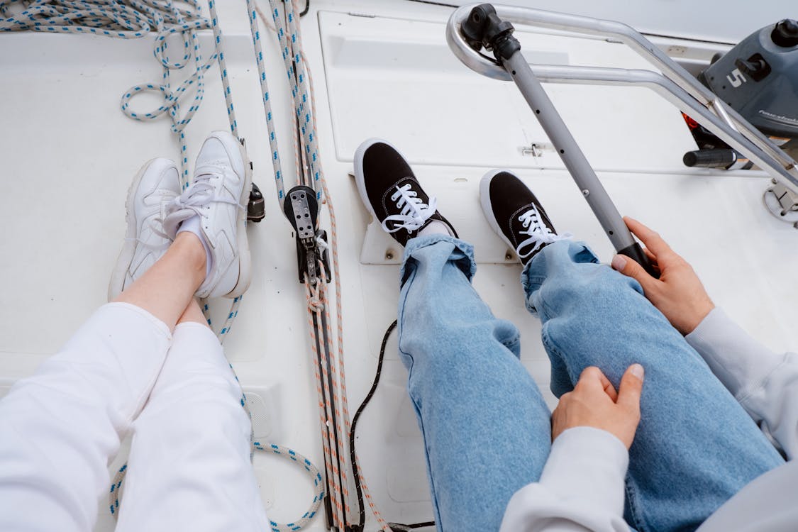 Two people relaxing on a yacht deck enjoying a sailing experience on the open sea