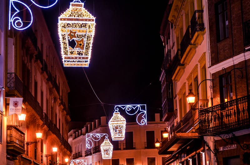 Street lanterns lighting a historic street in Seville Spain at evening time