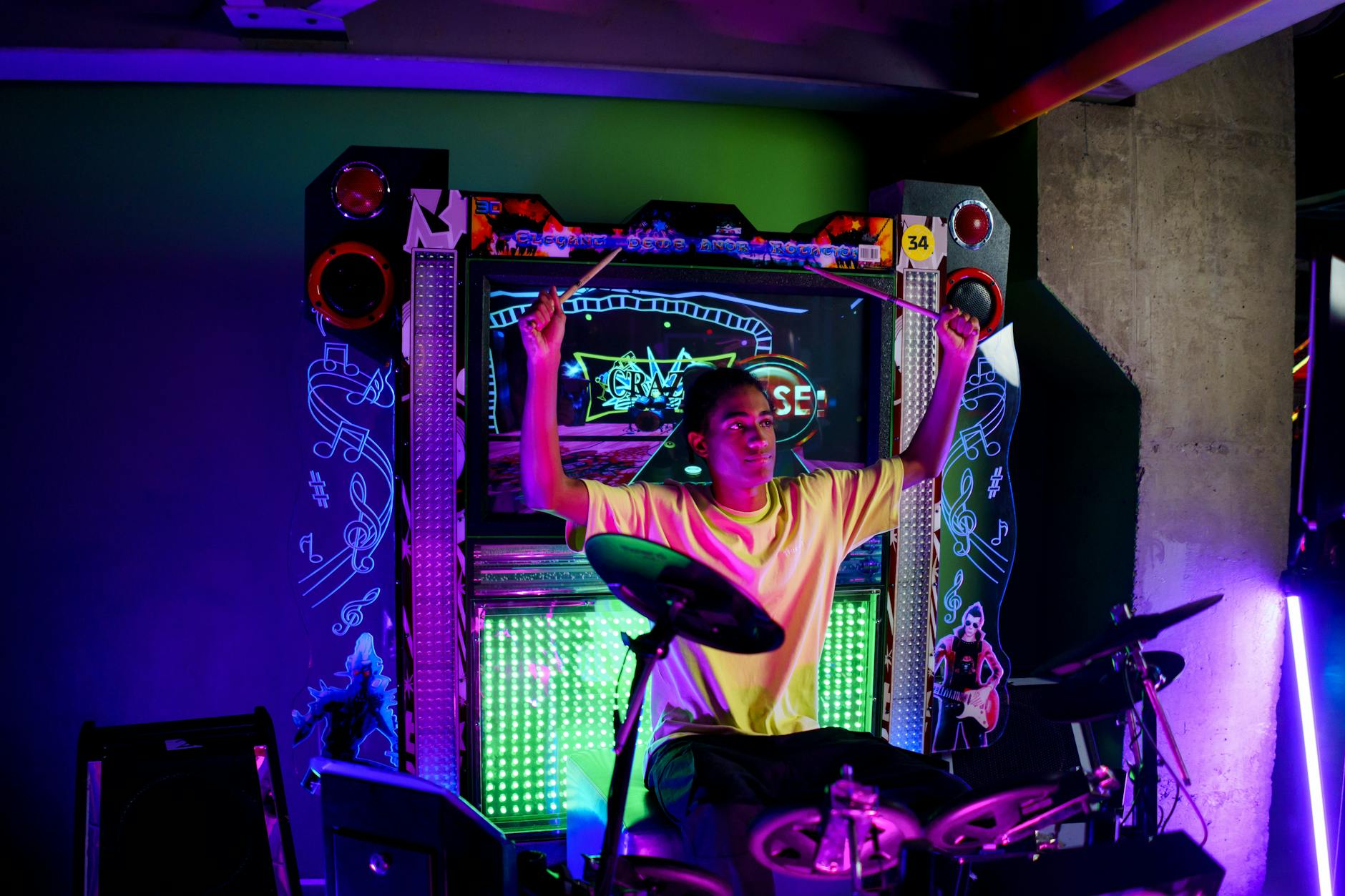 A young person at a bright neon-lit interactive entertainment display
