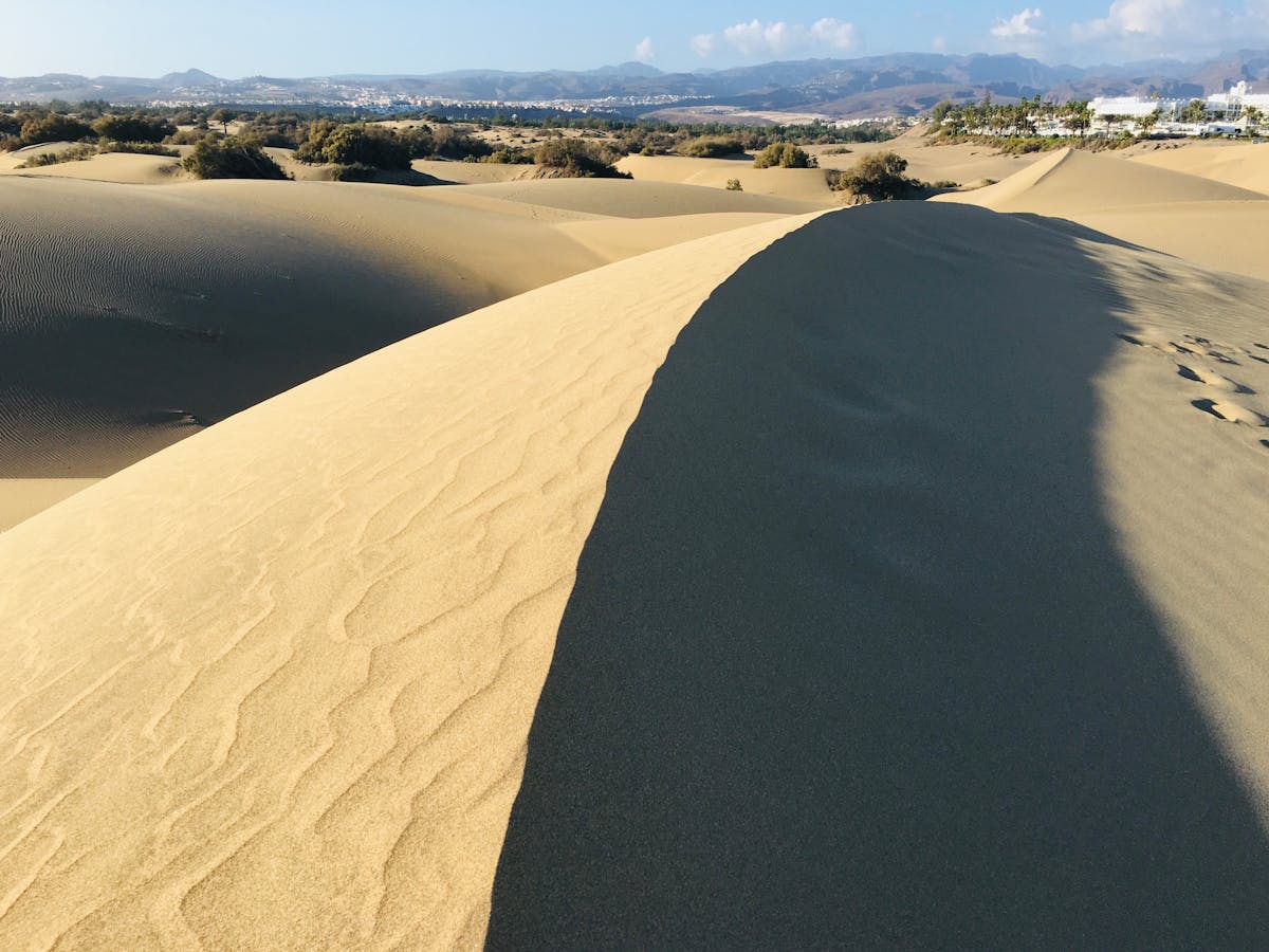 Expansive Maspalomas sand dunes under a bright blue sky in Gran Canaria