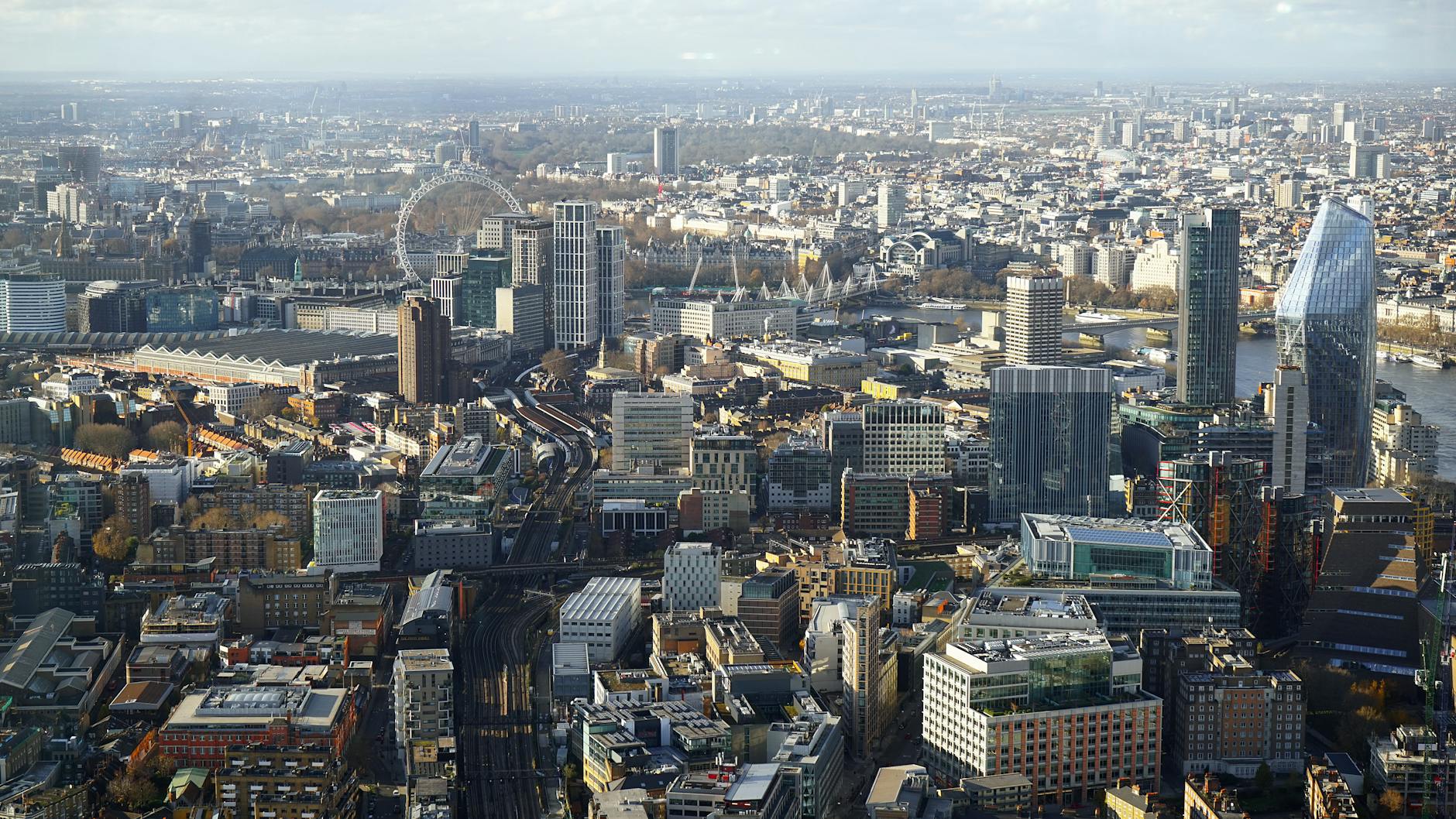 Wide aerial photograph showing London landmarks including the Thames, bridges, and city skyline