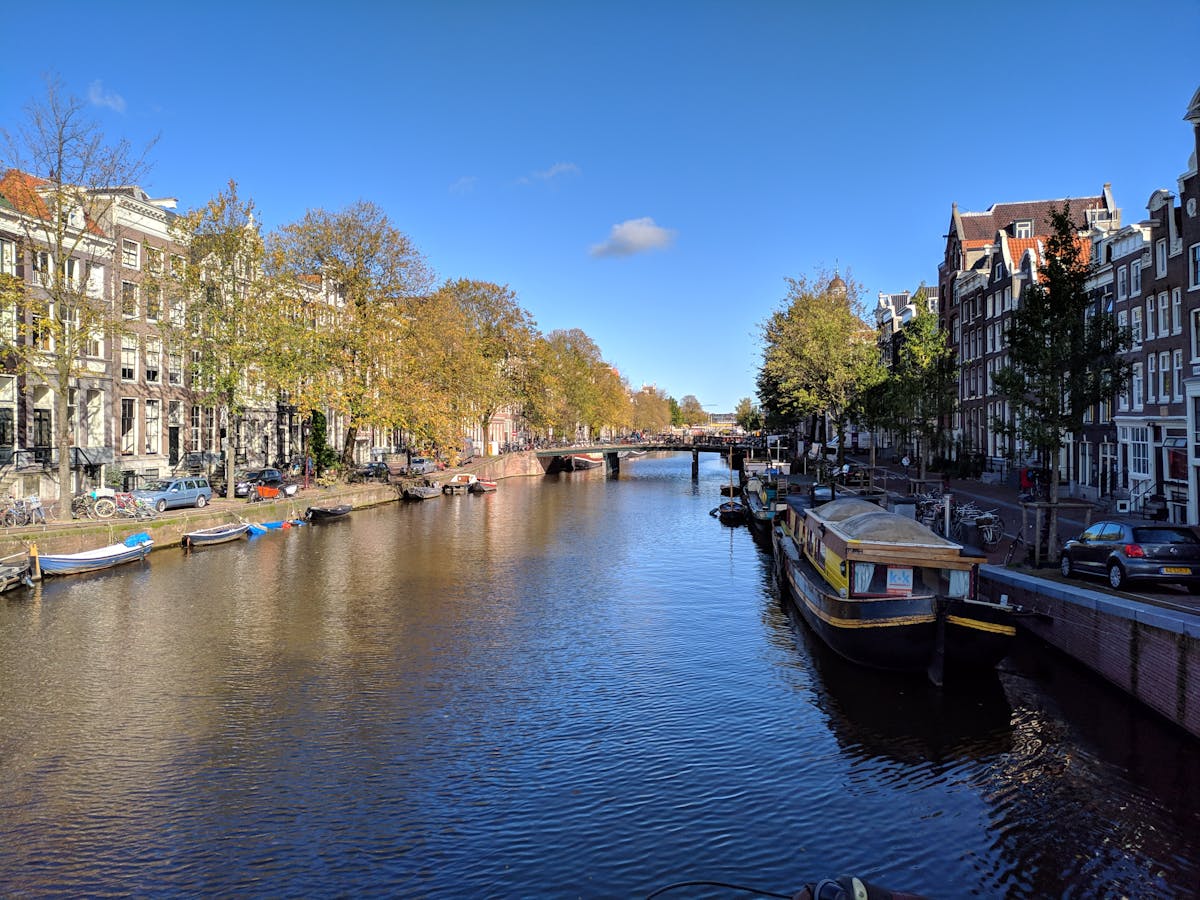Classic Amsterdam canal with historic houses and bright blue sky