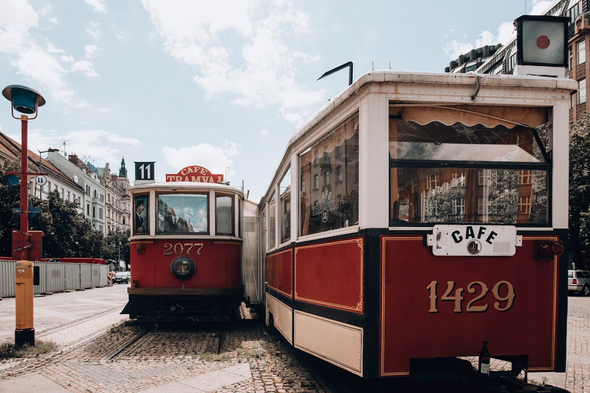 Vintage trams parked by a cafe on a Prague street