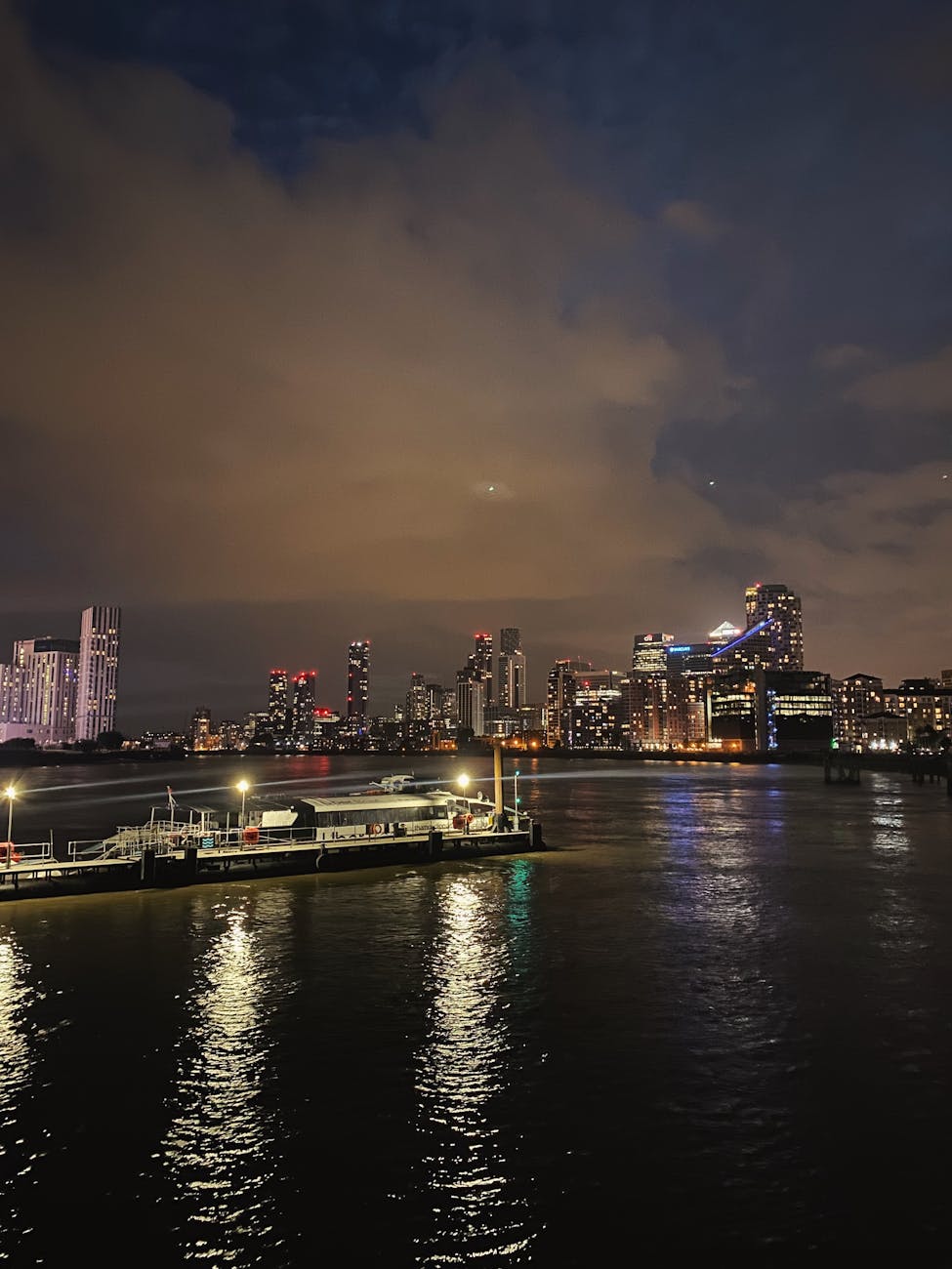 Illuminated London skyline at night with reflections on the River Thames
