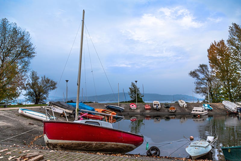 Small boats docked along the shore of Lake Maggiore during golden hour