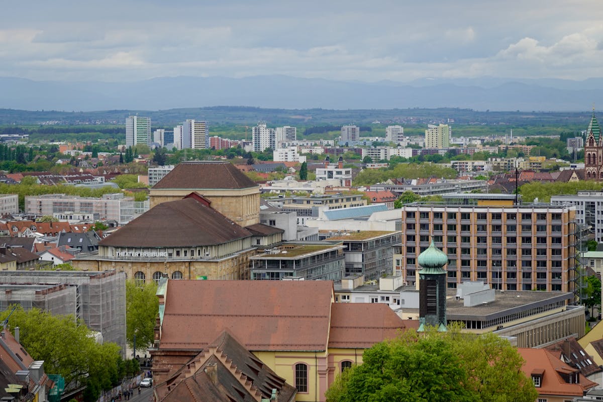 Scenic aerial view of Freiburg showcasing historic and modern architecture under a cloudy sky