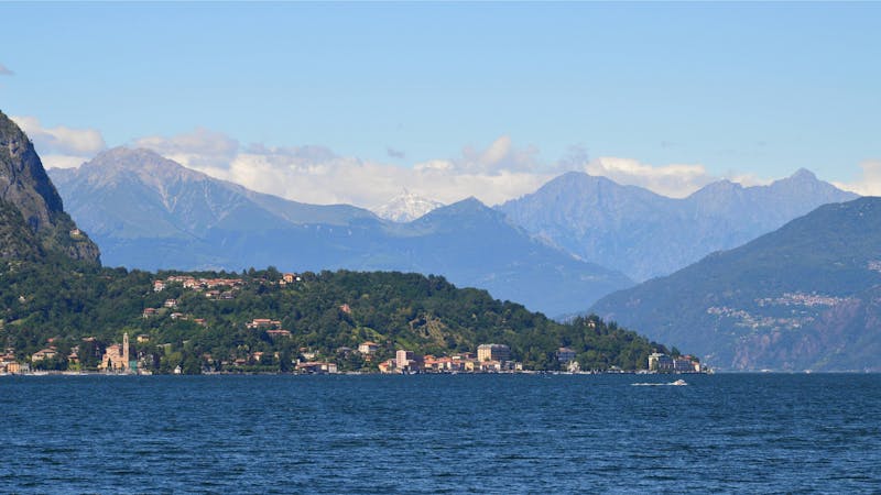 Lake Maggiore with Alpine mountains in the distance and green shoreline
