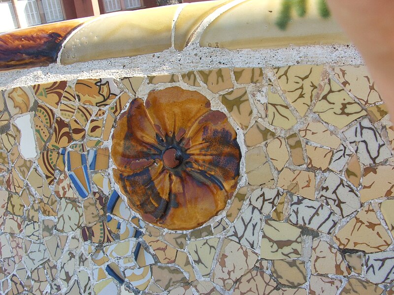 Close-up of colorful broken tile trencadis mosaic work on ceiling at Park Guell