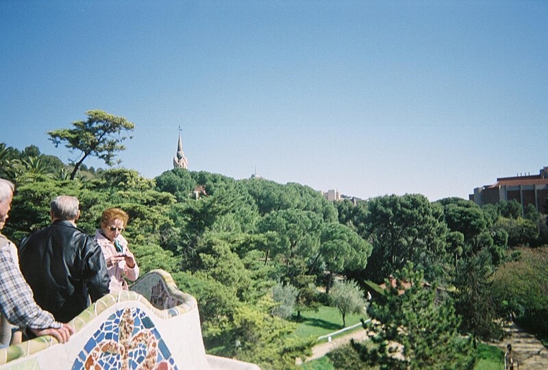 View from the serpentine bench terrace at Park Guell overlooking Barcelona rooftops and the sea