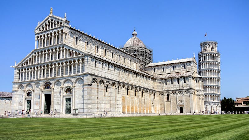 The Leaning Tower of Pisa and Pisa Cathedral under blue skies in Piazza dei Miracoli