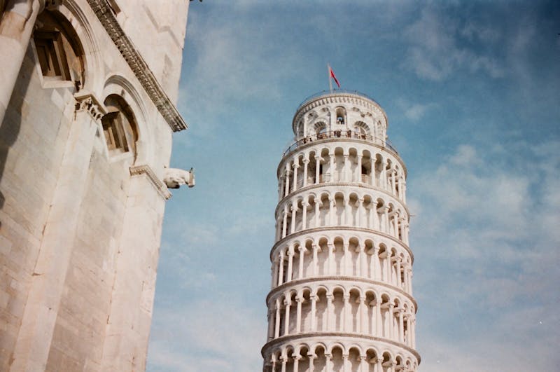 Low angle view of the Leaning Tower of Pisa showing its characteristic lean and marble columns