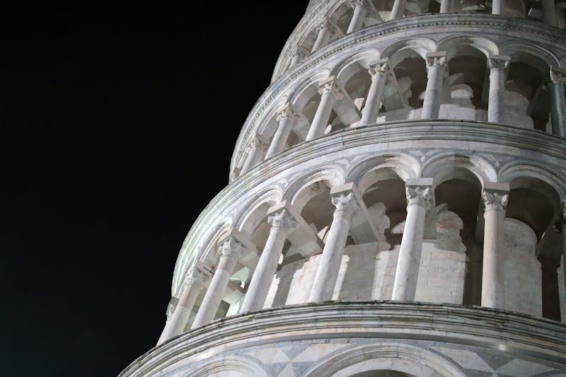 The Leaning Tower of Pisa lit up against the night sky