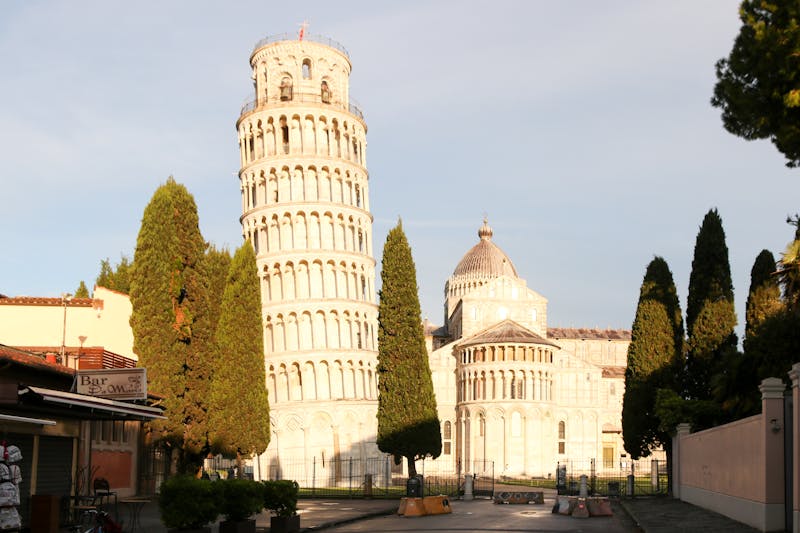 The iconic Leaning Tower of Pisa standing against a clear blue sky in Tuscany
