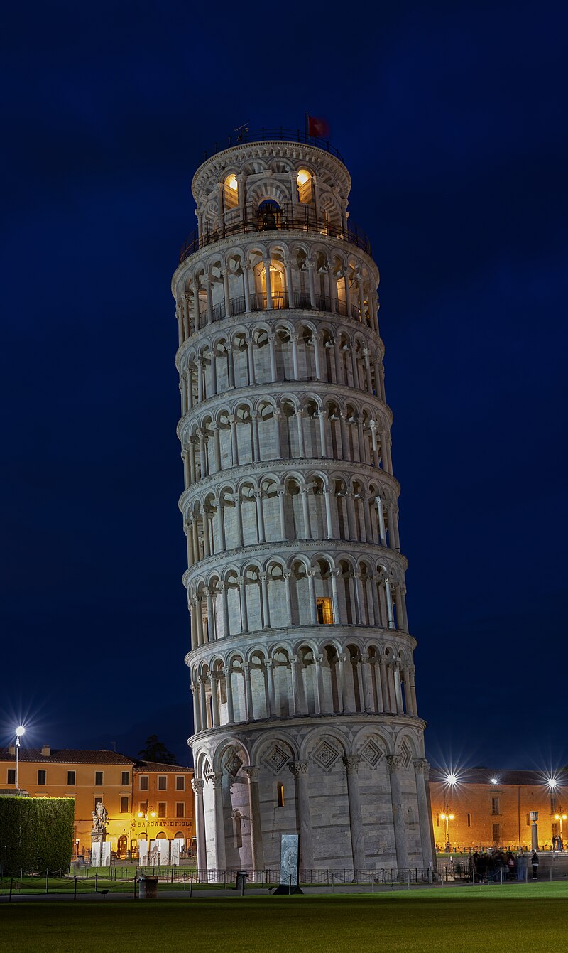 Close-up of the illuminated Leaning Tower of Pisa at night showing marble galleries