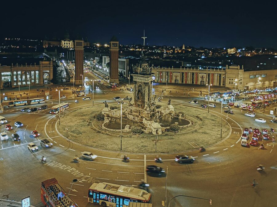 Illuminated Plaza de Espanya roundabout in Barcelona with city lights at night