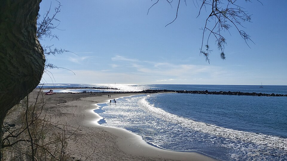 Sandy beach Playa de Troya in Costa Adeje with sunbathers and blue water