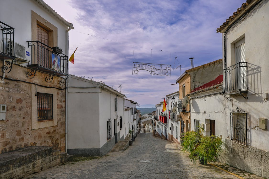 Traditional Spanish village street with stone buildings and terracotta roofs