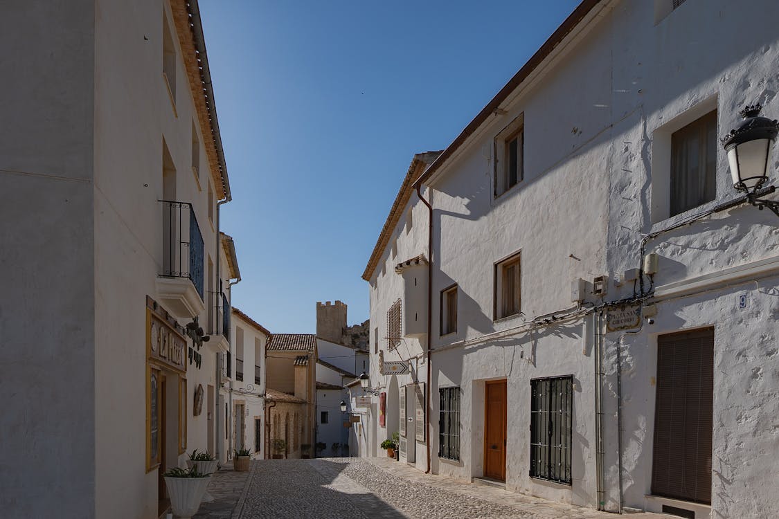 Whitewashed Mediterranean village street with blue accents and plants