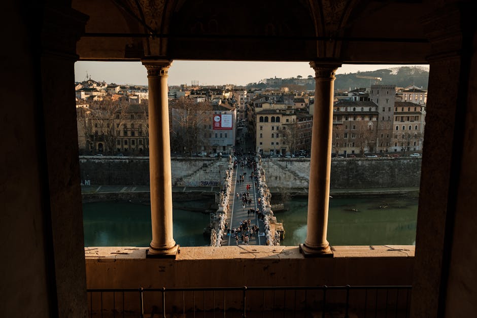 Crowds of people crossing Ponte Sisto bridge in Rome at sunset with historic buildings in background