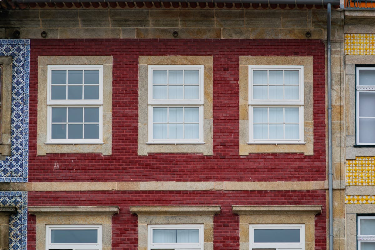Red brick building facade with traditional Portuguese white windows in Porto historic district
