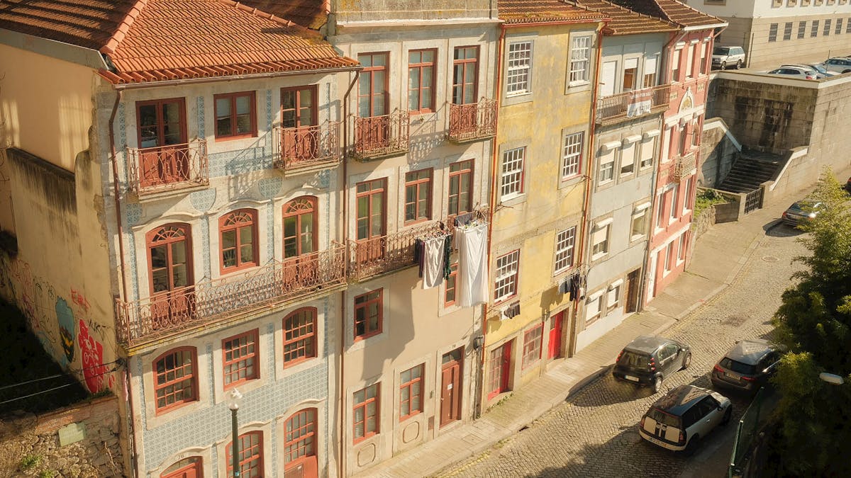 Sunlit vintage buildings on a Porto street showcasing classic azulejo tiles and traditional architecture