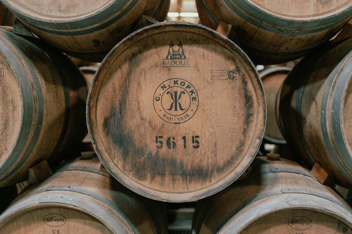 Wooden wine barrels aging in rows inside a traditional port wine cellar in Porto Portugal