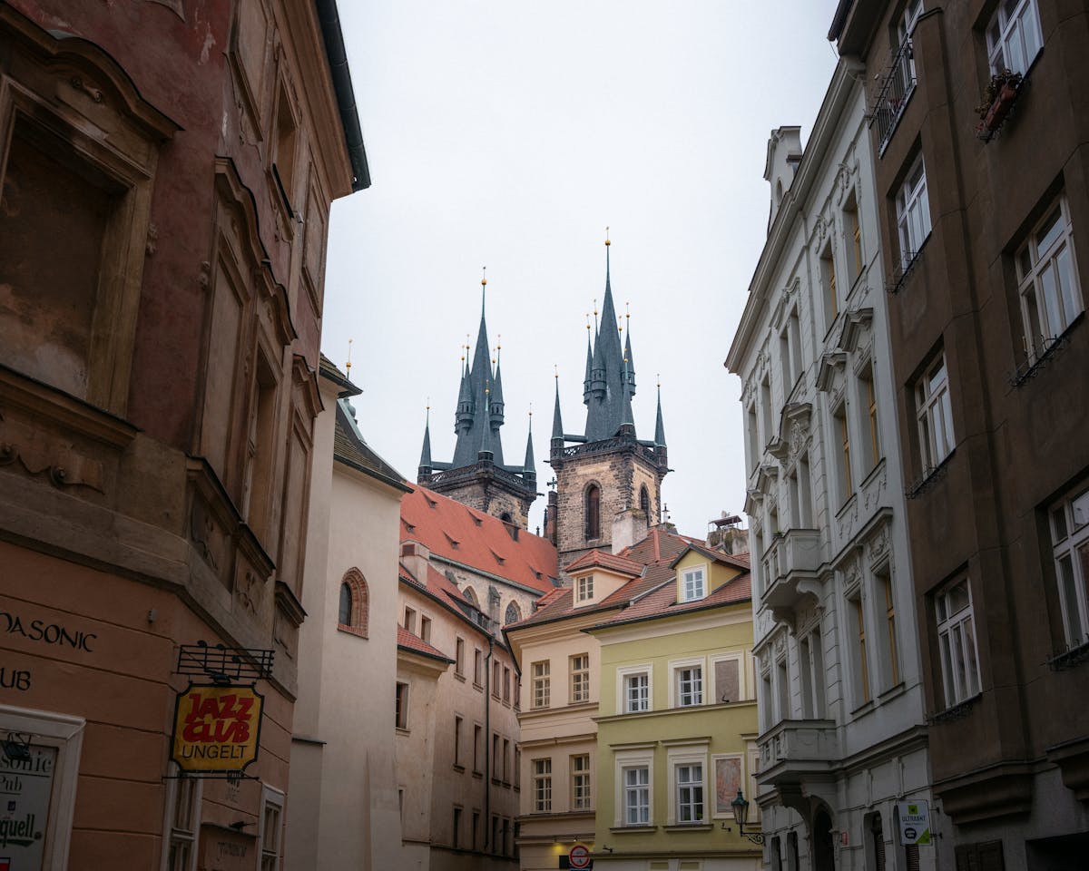 View of Gothic church spires framed by historic architecture in Prague Old Town