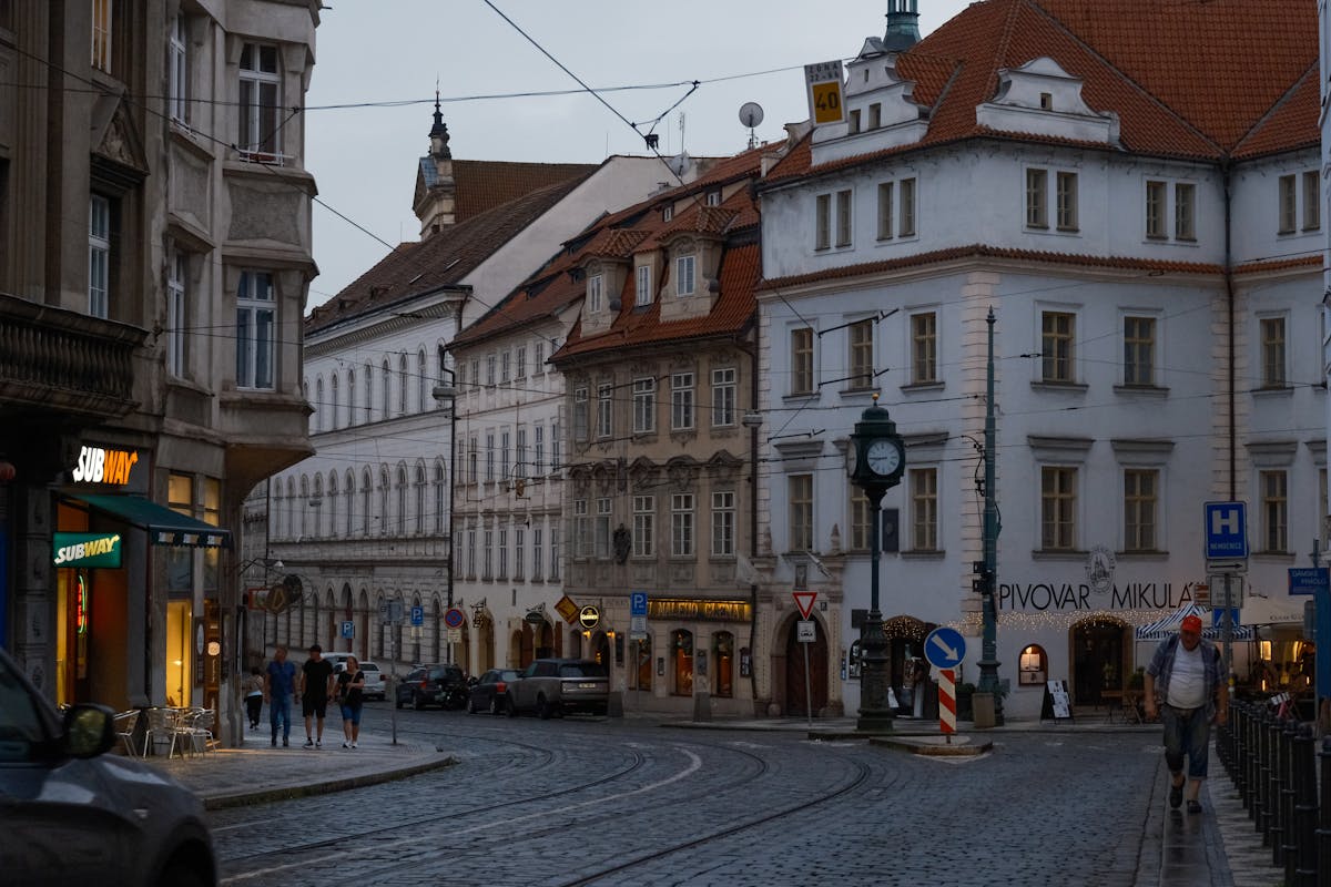 Charming Prague street with historic buildings illuminated at dusk