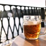 Refreshing lager beer mug with scenic Prague river view in background