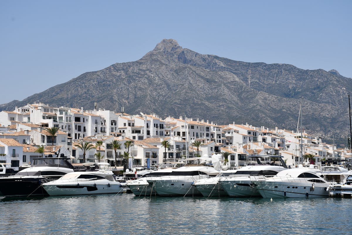 Luxury yachts docked at Puerto Banus with mountain backdrop