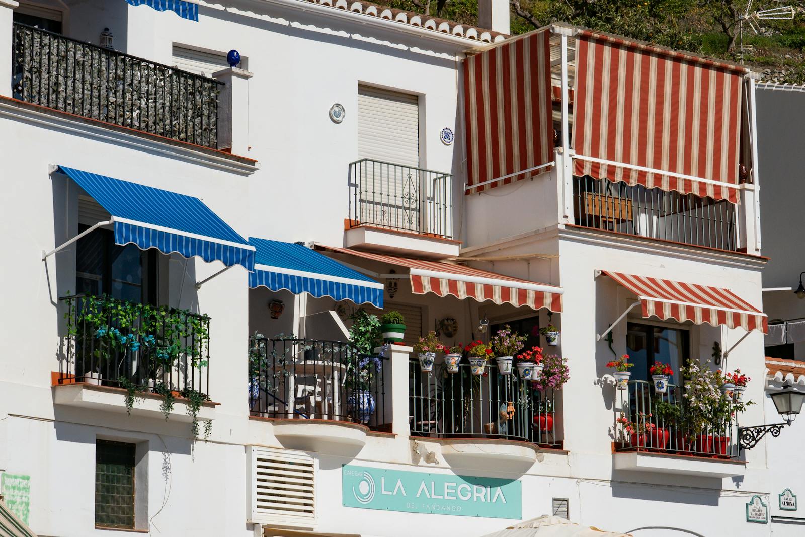 Traditional architecture of Frigiliana with colorful awnings and flower-laden balconies